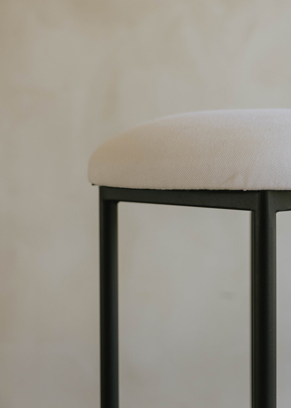 Taburete de forja sin respaldo y tapizado blanco MRGO Arquitectos – Canica